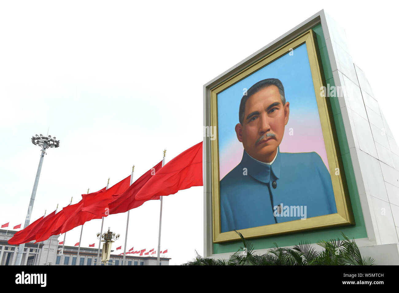 Red flags flutter beside a huge portrait of Chinese revolutionary ...