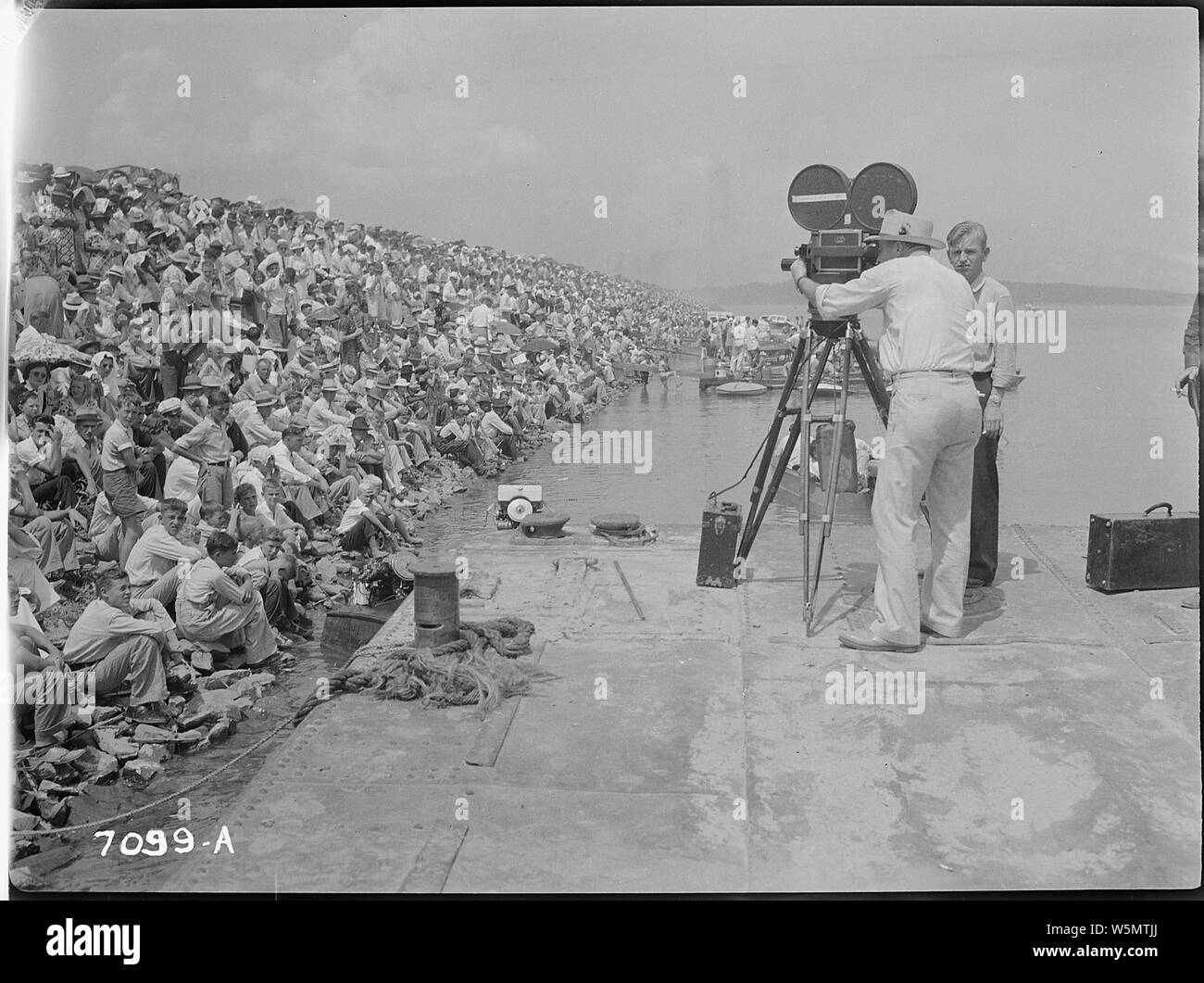 Fox Movietone cameraman takes a peel of the crowd at dam dedication ...