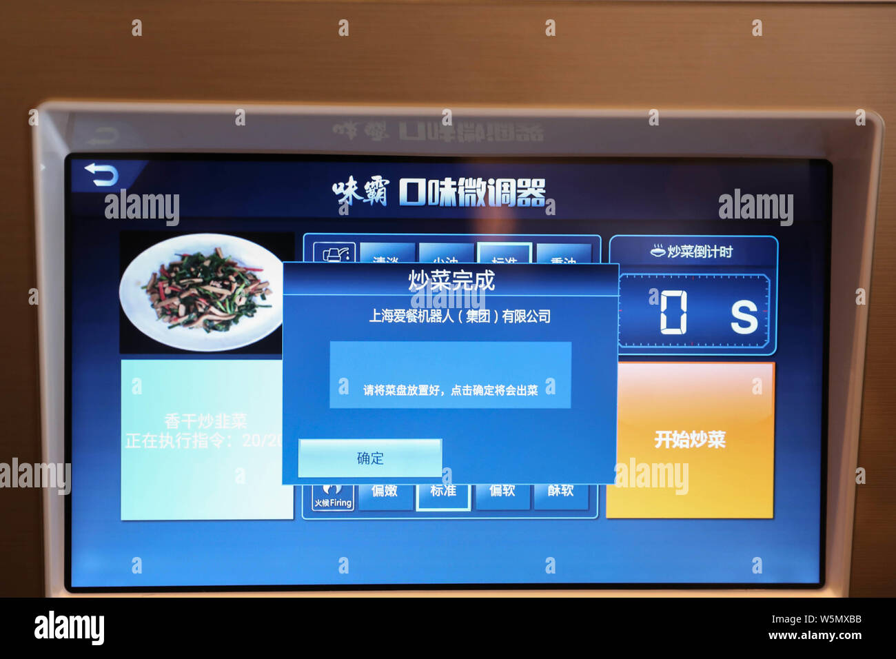 A Chinese man operates a robotic chef produced by aicanwang.com to make ...