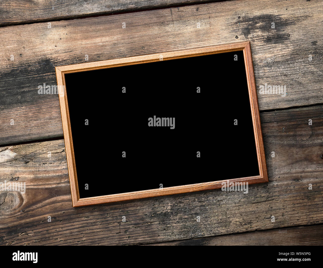 rectangular brown wooden frame on a background of very old boards ...