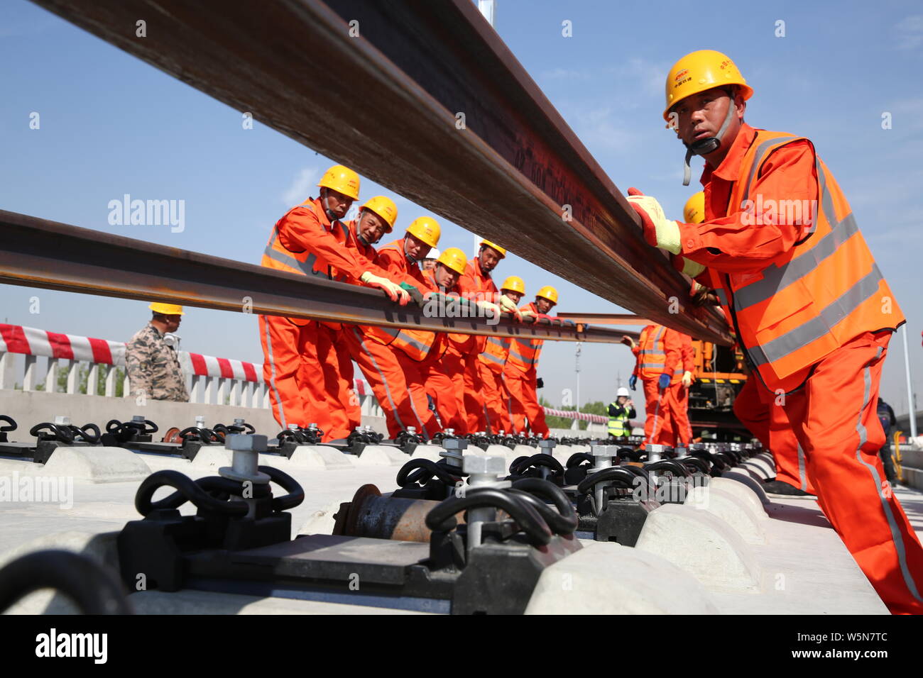 Chinese workers lay the tracks for the Beijing section of the Beijing ...