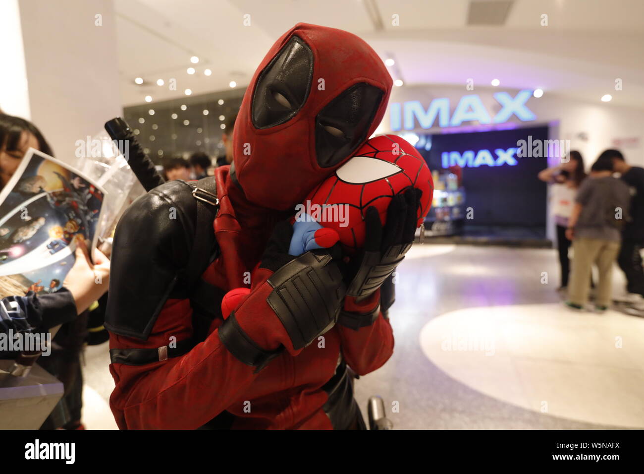 A Chinese filmgoer wearing costume of Deadpool waits inside a cinema ...