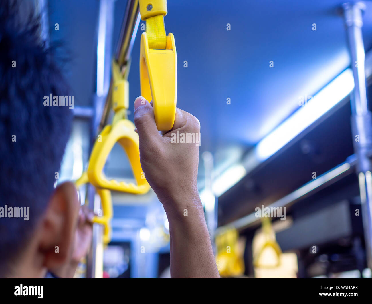 Close-up hand holding yellow handle in the shuttle bus in airport Stock ...