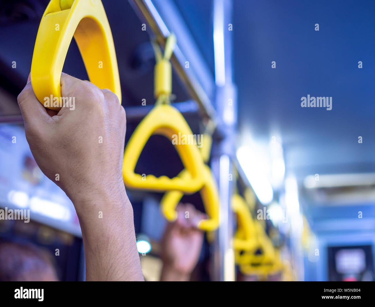 Close-up hand holding yellow handle in the shuttle bus in airport Stock ...