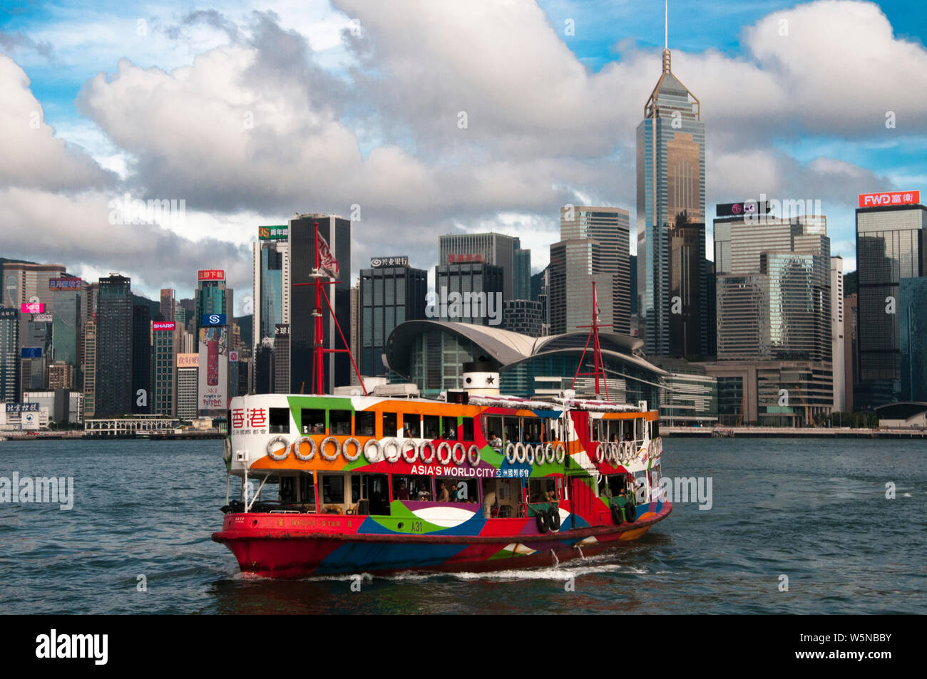 Emblazoned with advertising, a brightly-decorated Star Ferry steams ...
