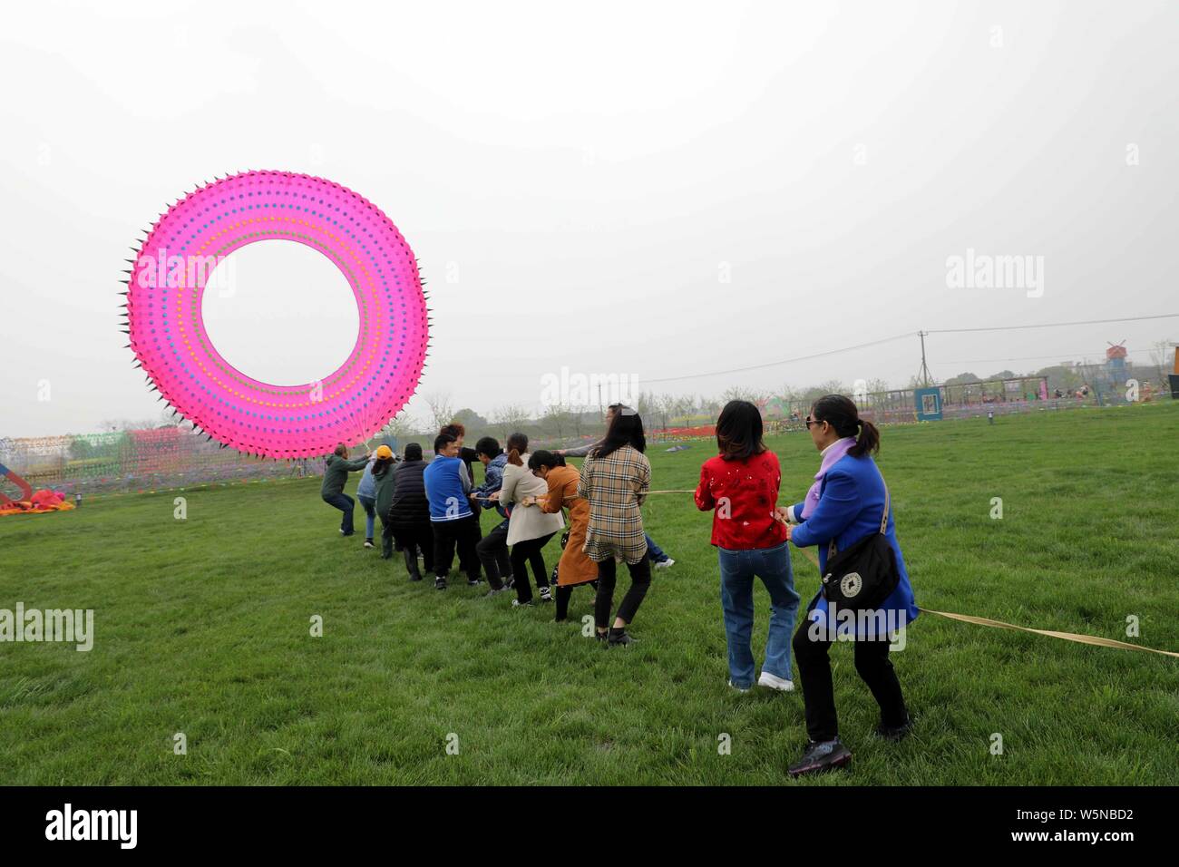 More than 10 people fly a huge kite known as the "ground-rolling dragon ...