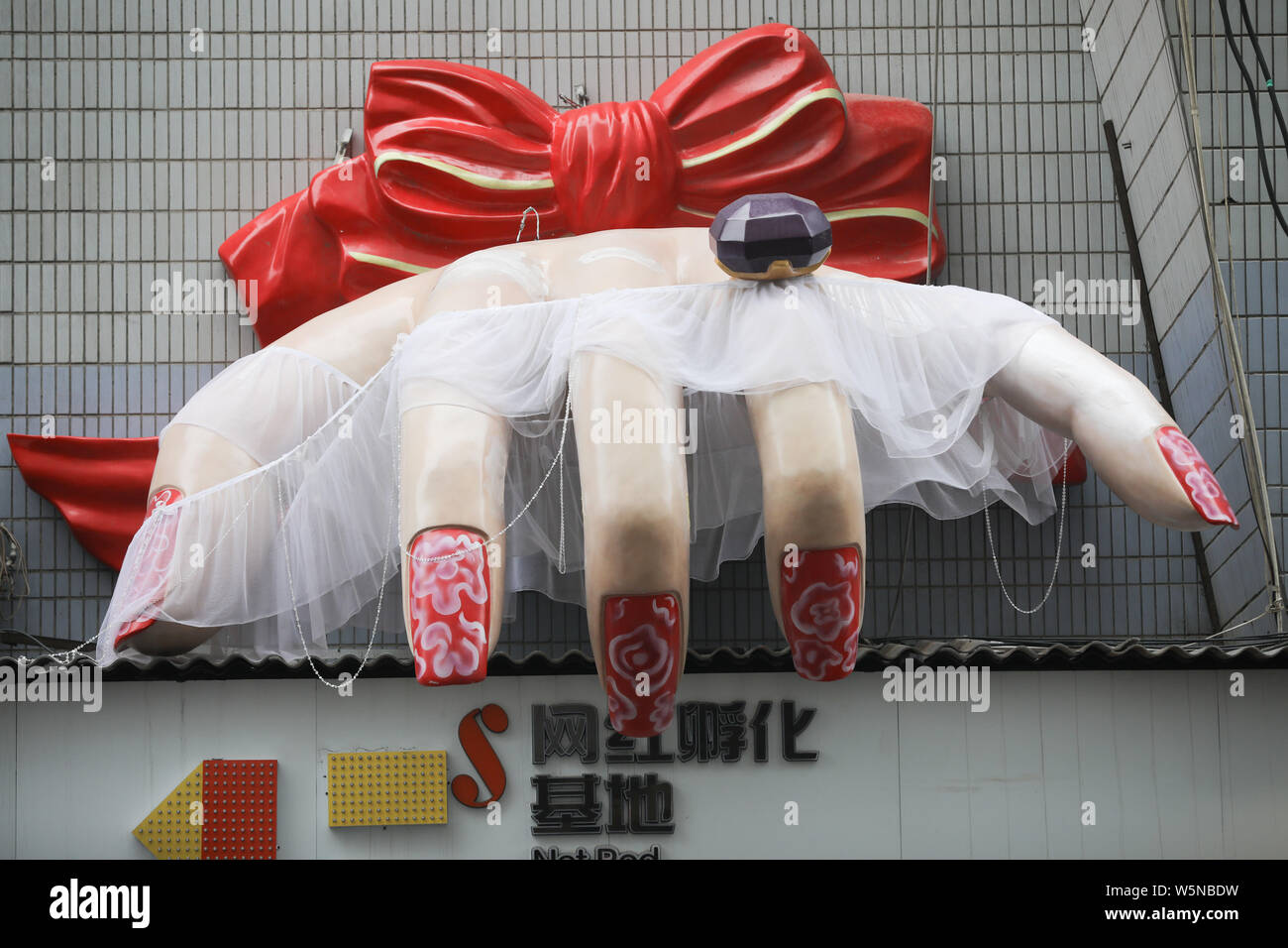 A huge sculpture featuring shape of a hand covered with white yarn is ...