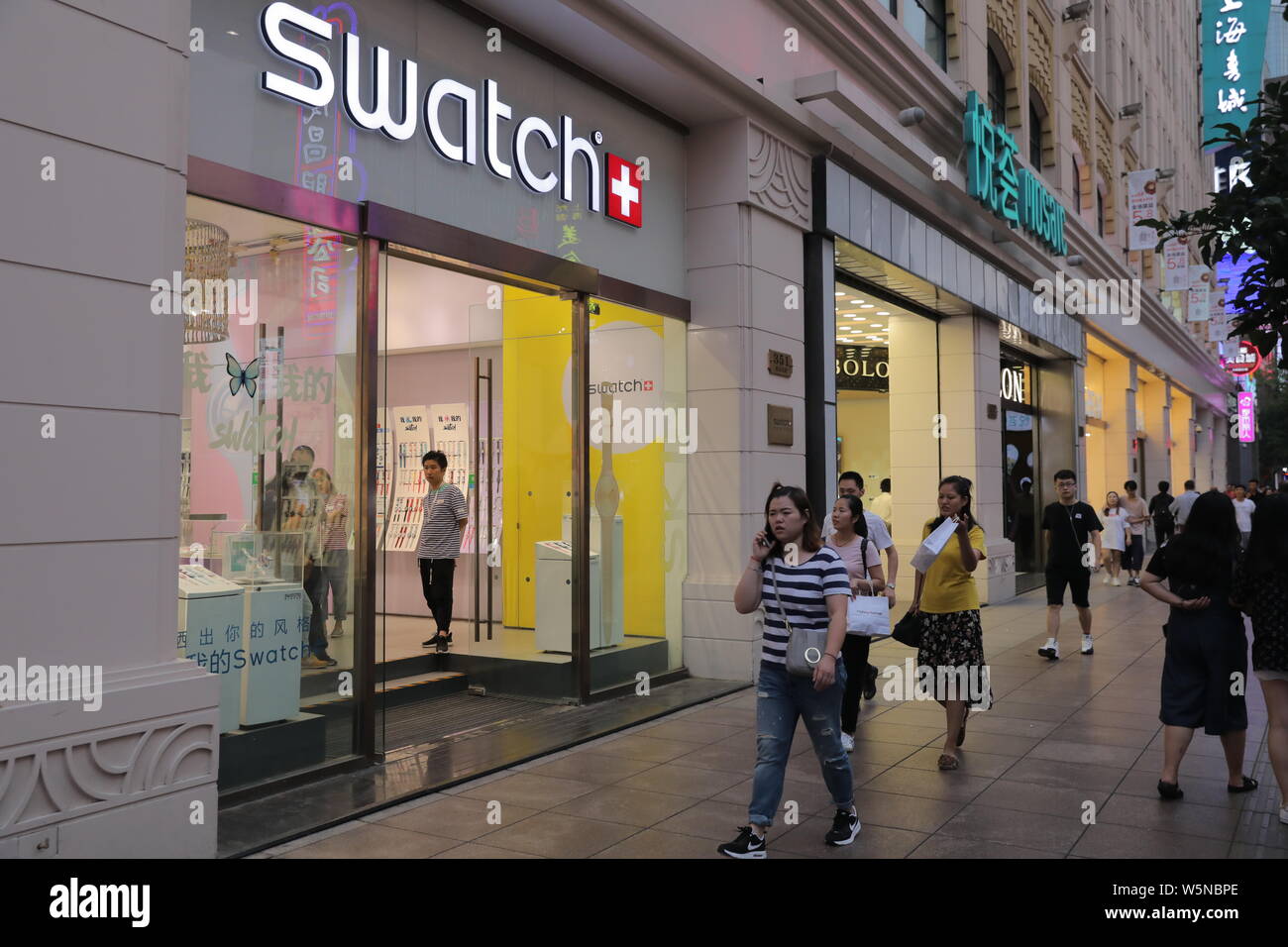 --FILE--Pedestrians walk past a store of Swiss watchmaker Swatch in ...