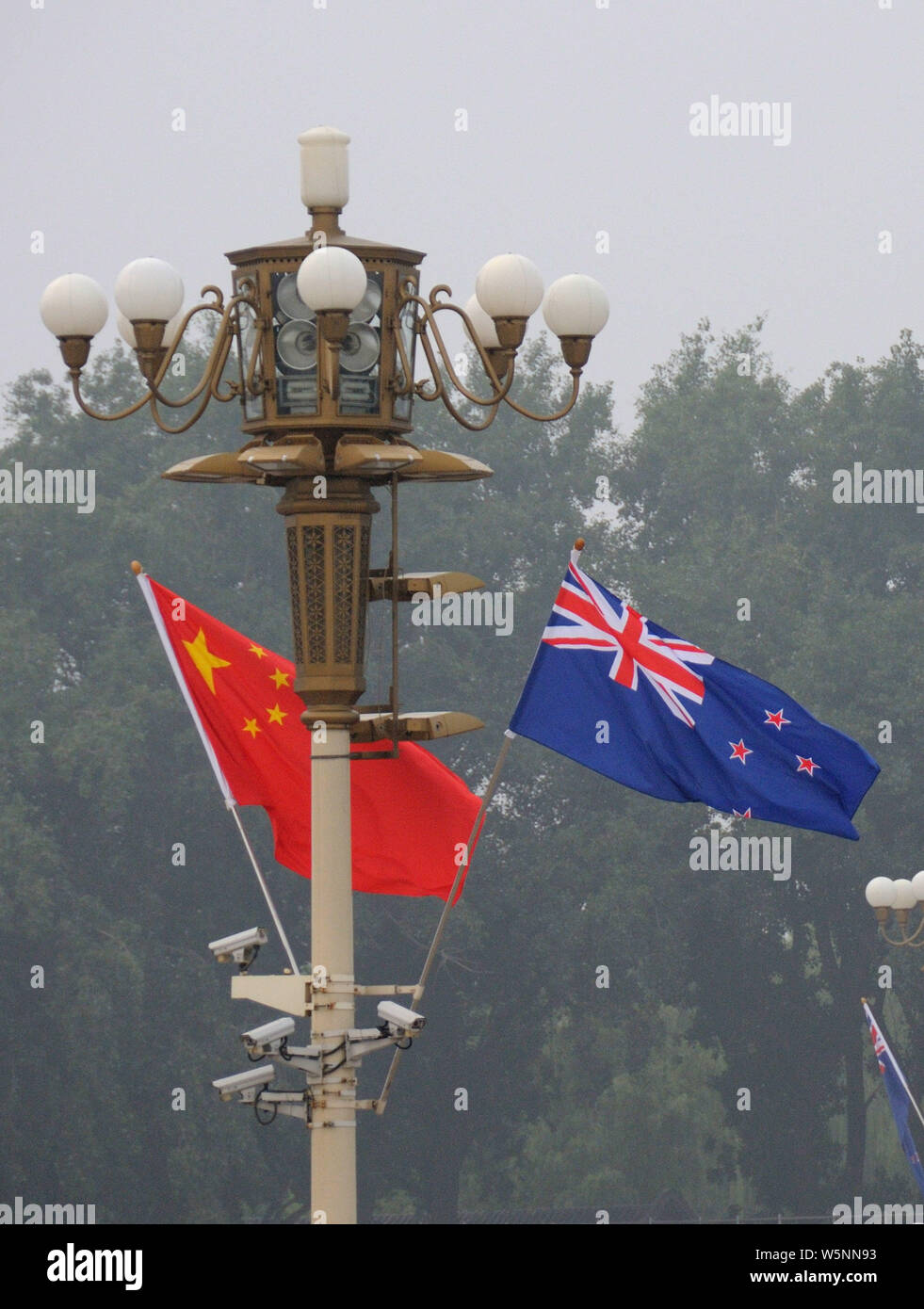 --FILE--Chinese and New Zealand national flags flutter on a lamppost on ...