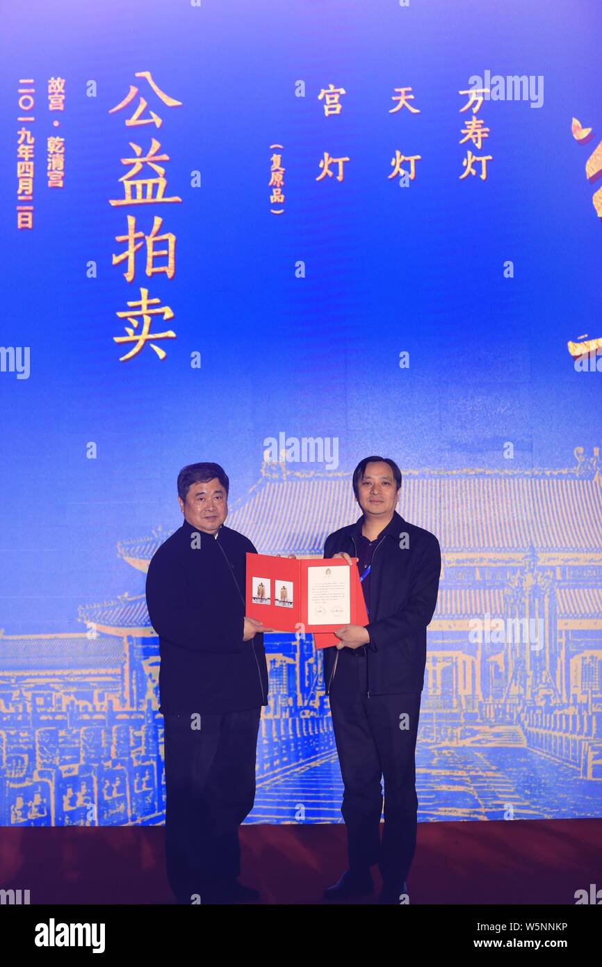 Shan Jixiang, left, the museum curator, issues the certificate for a ...