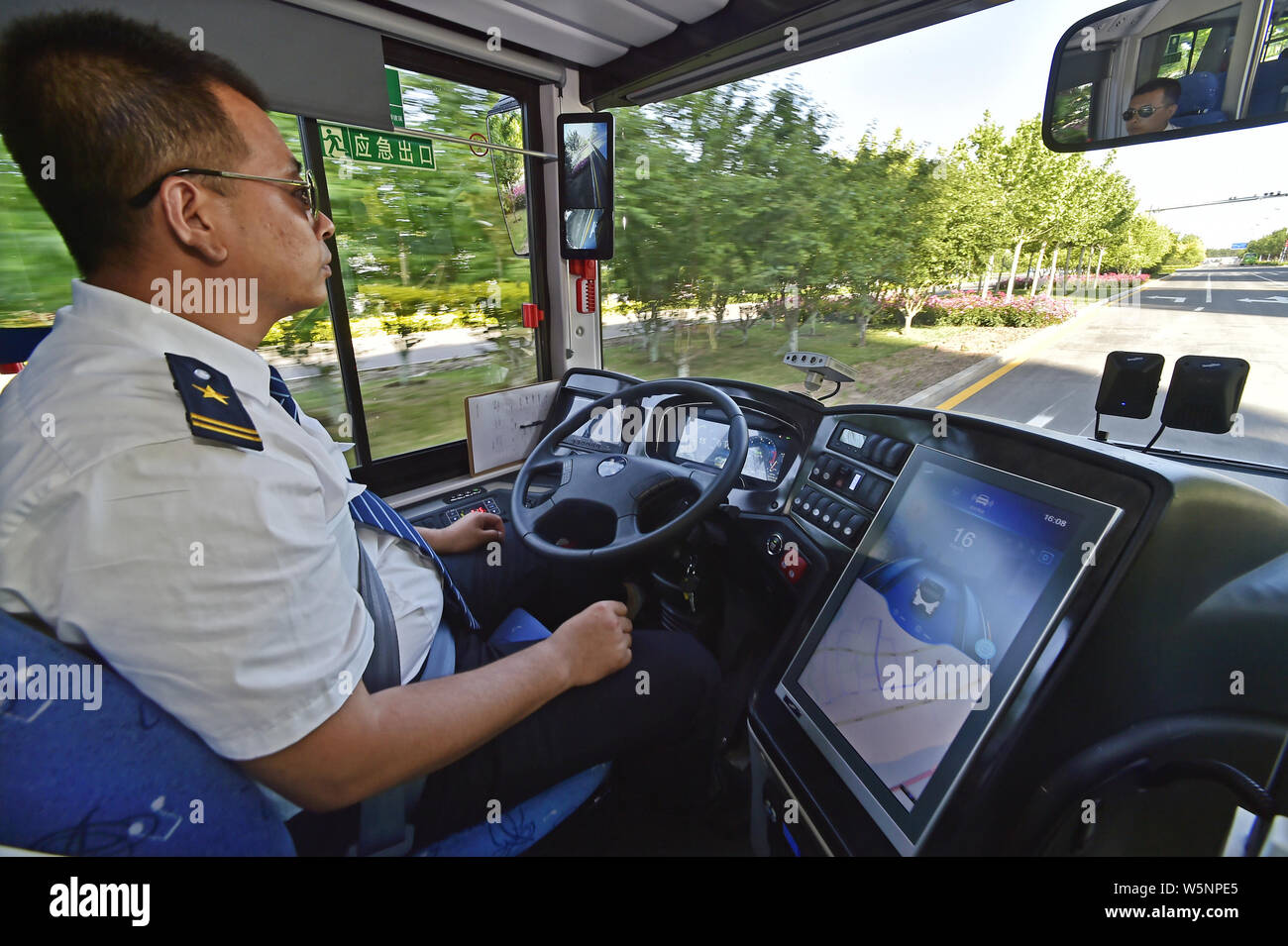 A driver operates a multi-functional AI-based autonomous driving bus ...