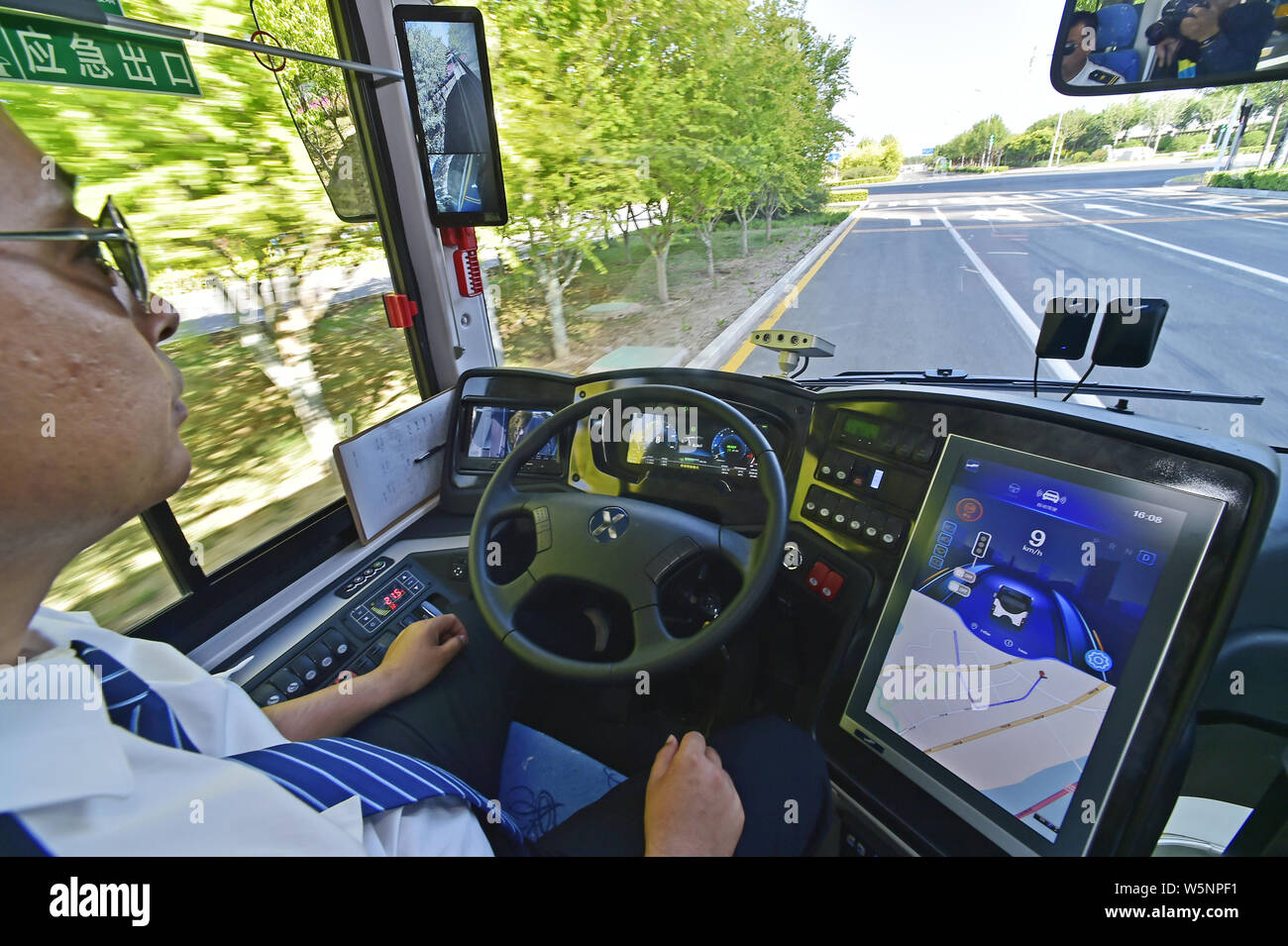 A driver operates a multi-functional AI-based autonomous driving bus ...