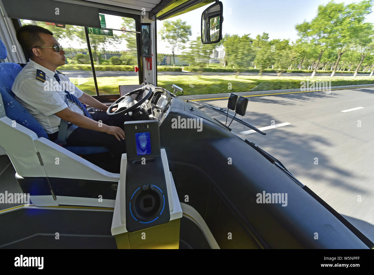 A driver operates a multi-functional AI-based autonomous driving bus ...
