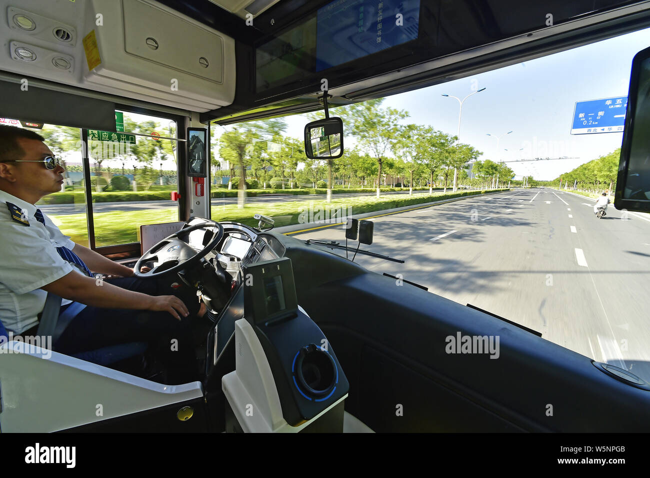 A driver operates a multi-functional AI-based autonomous driving bus ...