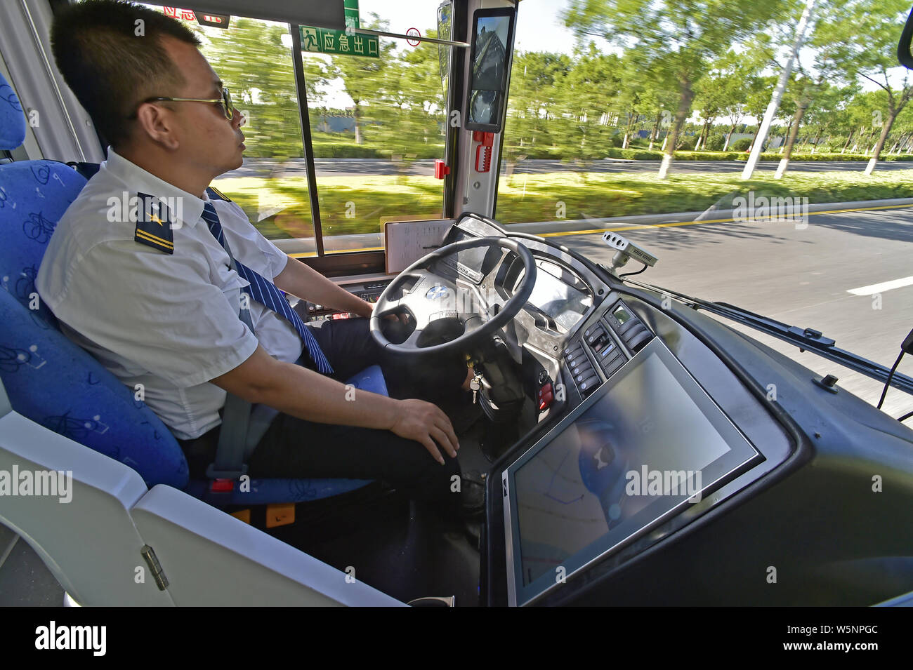 A driver operates a multi-functional AI-based autonomous driving bus ...