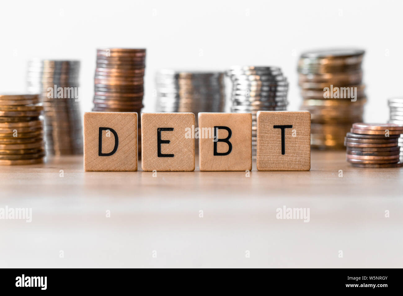 Debt sign with coins in the background Stock Photo - Alamy