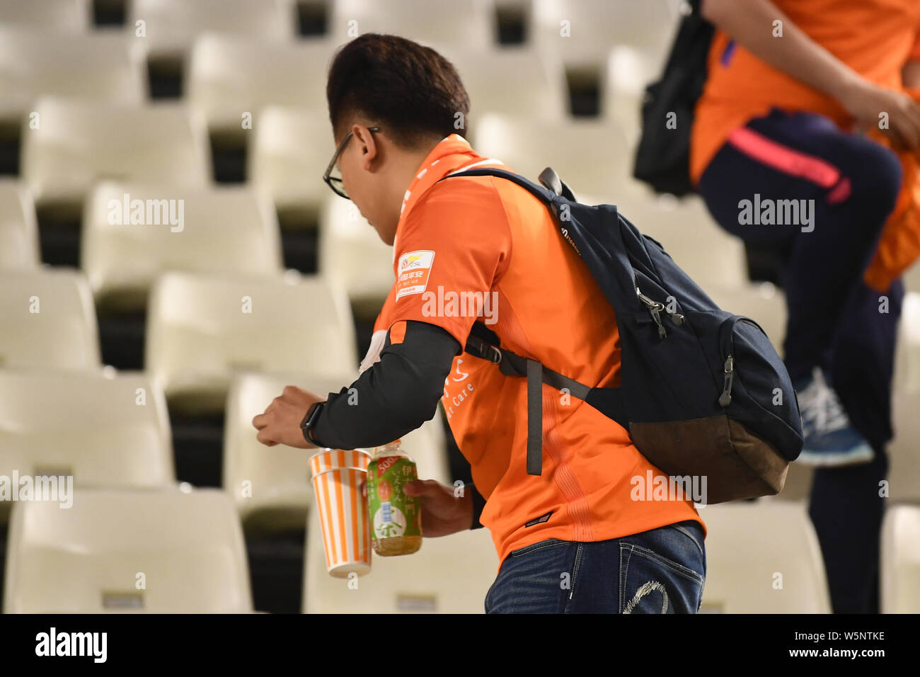 A Chinese football fan cleans the stadium's stand after China's ...
