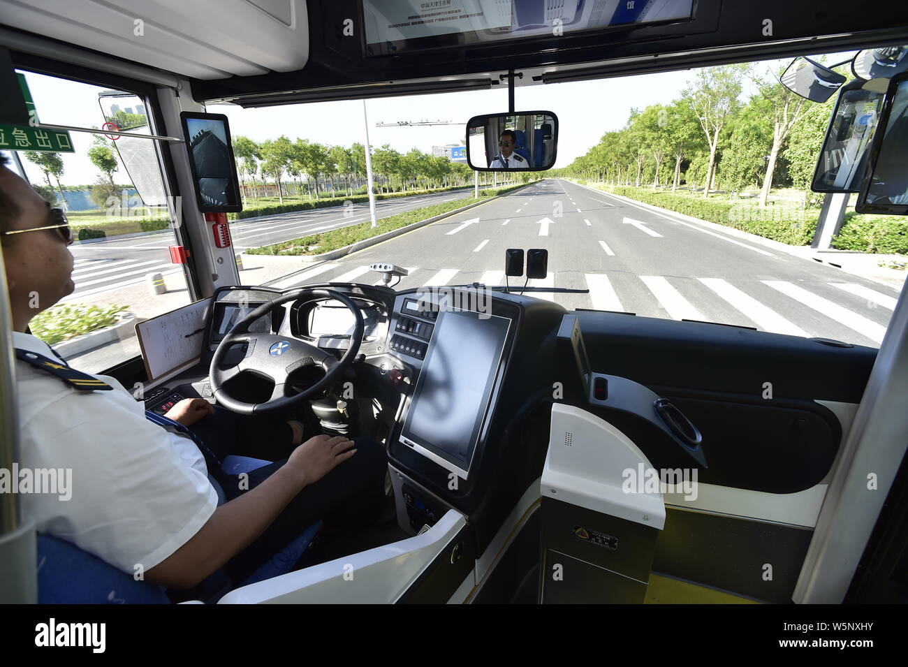 A driver operates a multi-functional AI-based autonomous driving bus ...