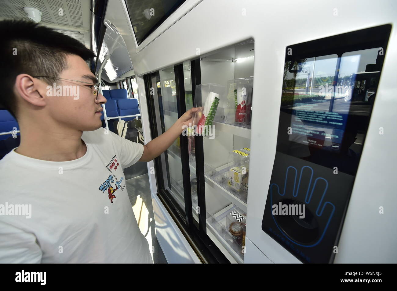 A passenger swipes his hand through a fingerprint recognition system to ...