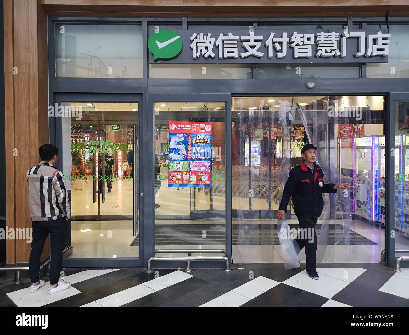--FILE--A customer walk past a logo of WeChat Pay at a shopping mall in ...