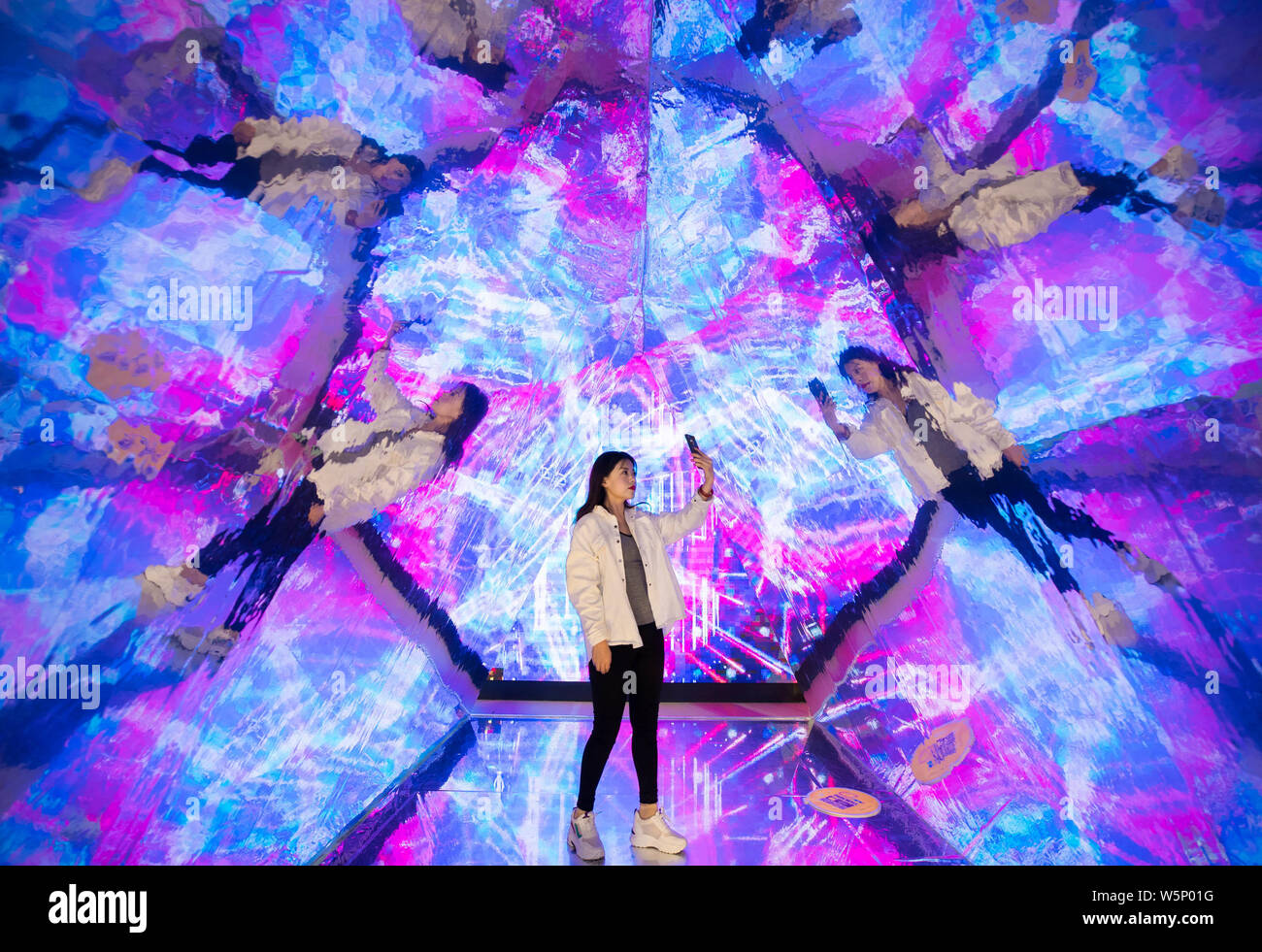Visitors pose for photos in an image tunnel featuring theme of ...