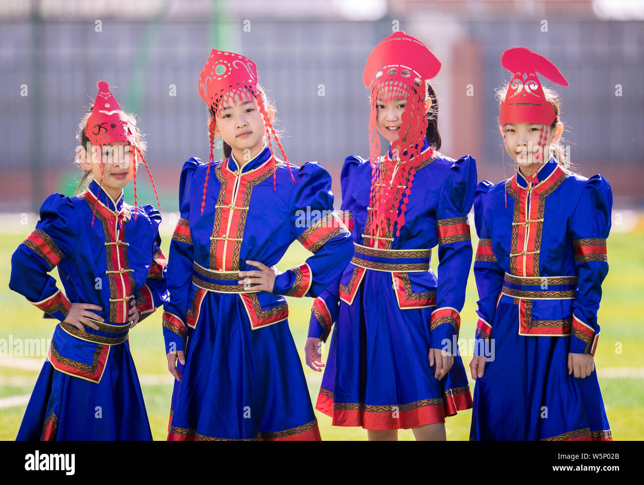Chinese primary students dressed in traditional costumes and wearing ...