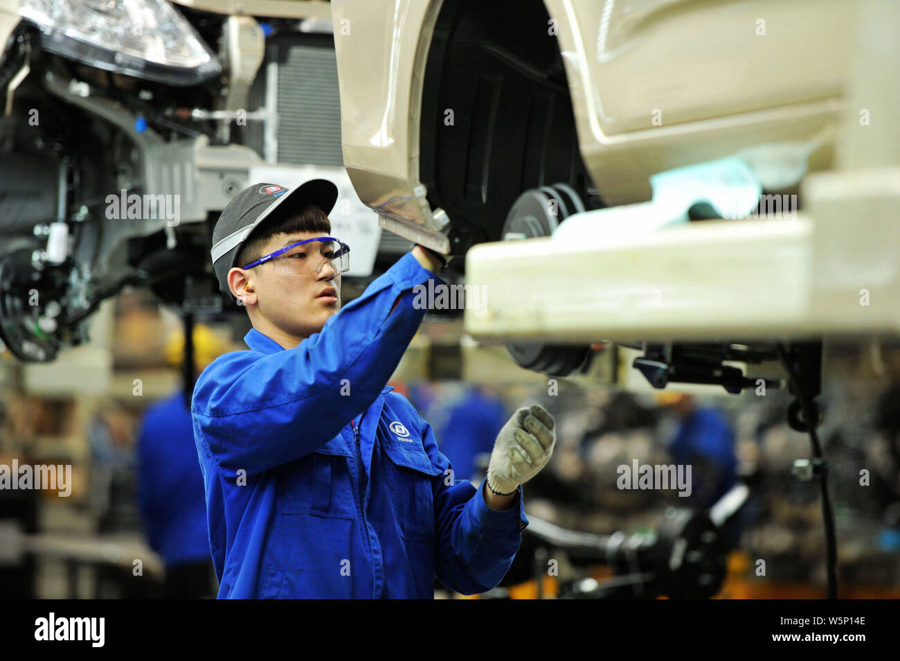 --FILE--A Chinese worker assembles cars on the assembly line at the ...