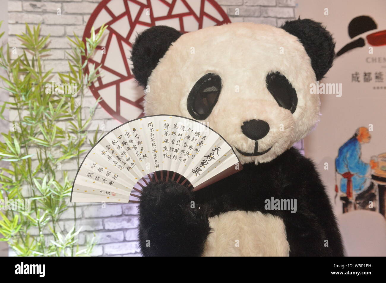 A Chinese worker dressed in panda costume poses during the opening ...