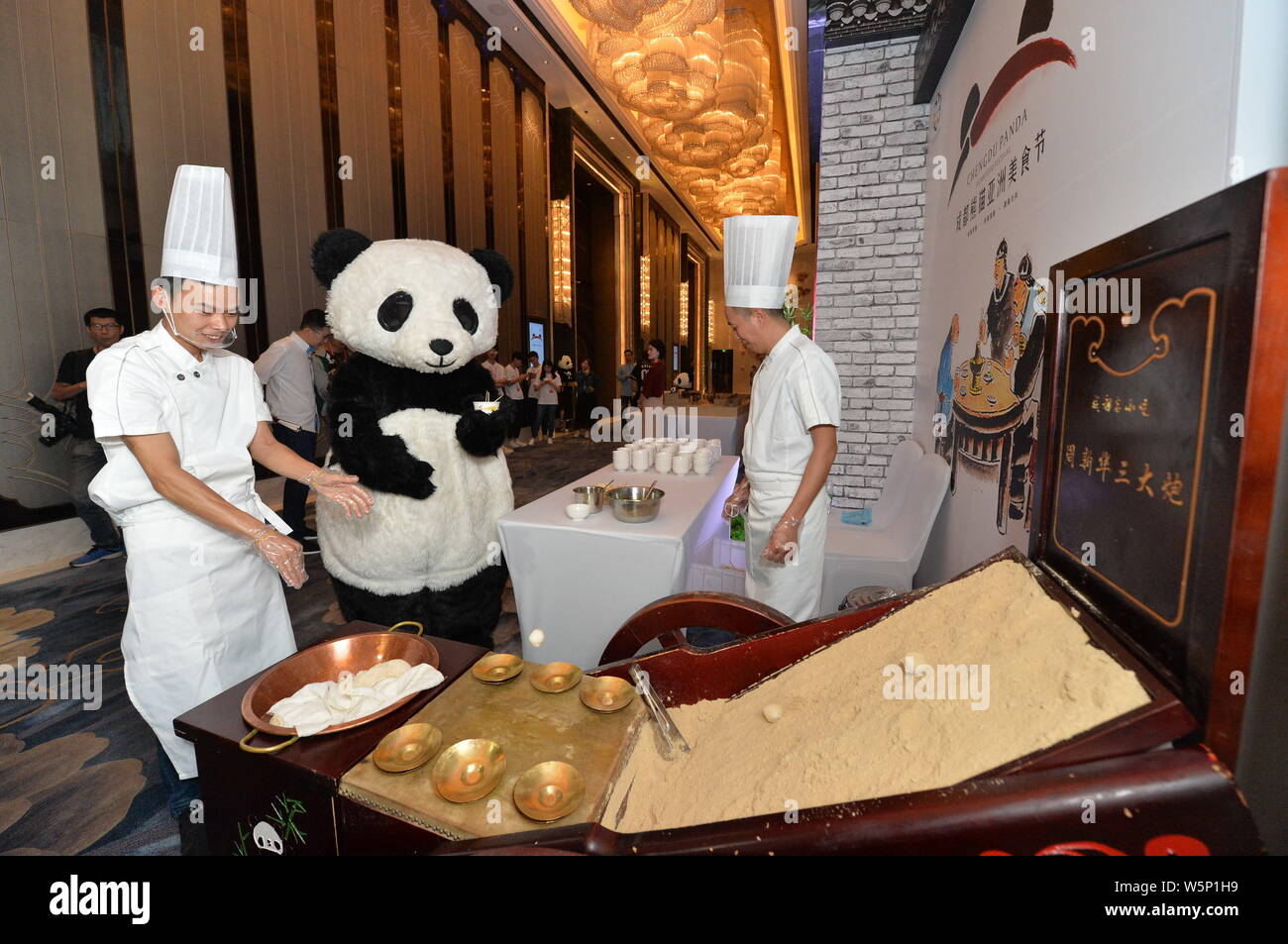 A Chinese worker dressed in panda costume poses during the opening ...