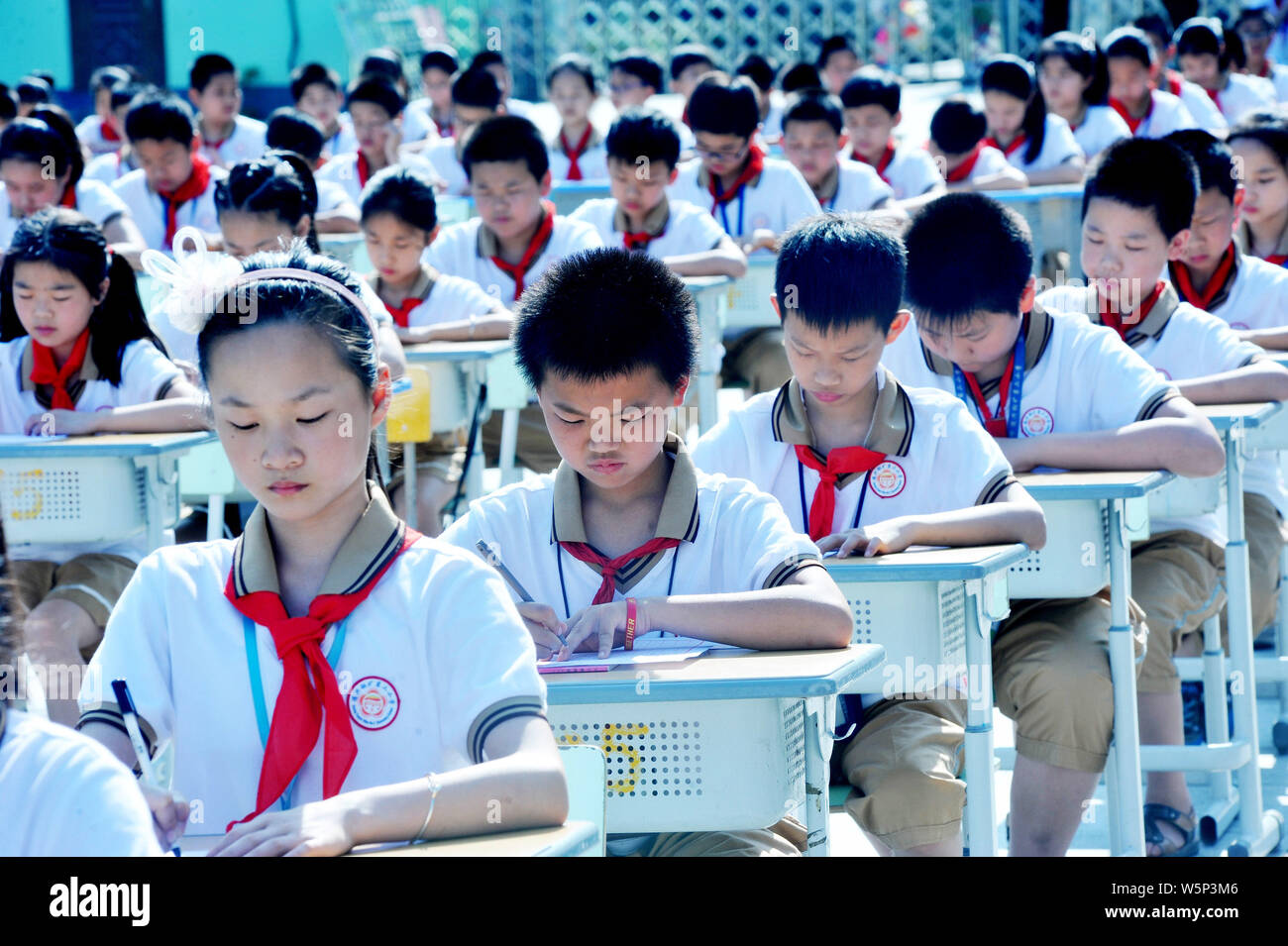 Chinese primary school students sit in rows as they practice ...