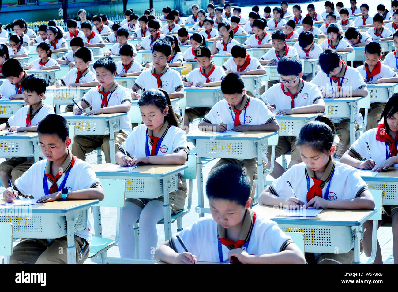Chinese primary school students sit in rows as they practice ...