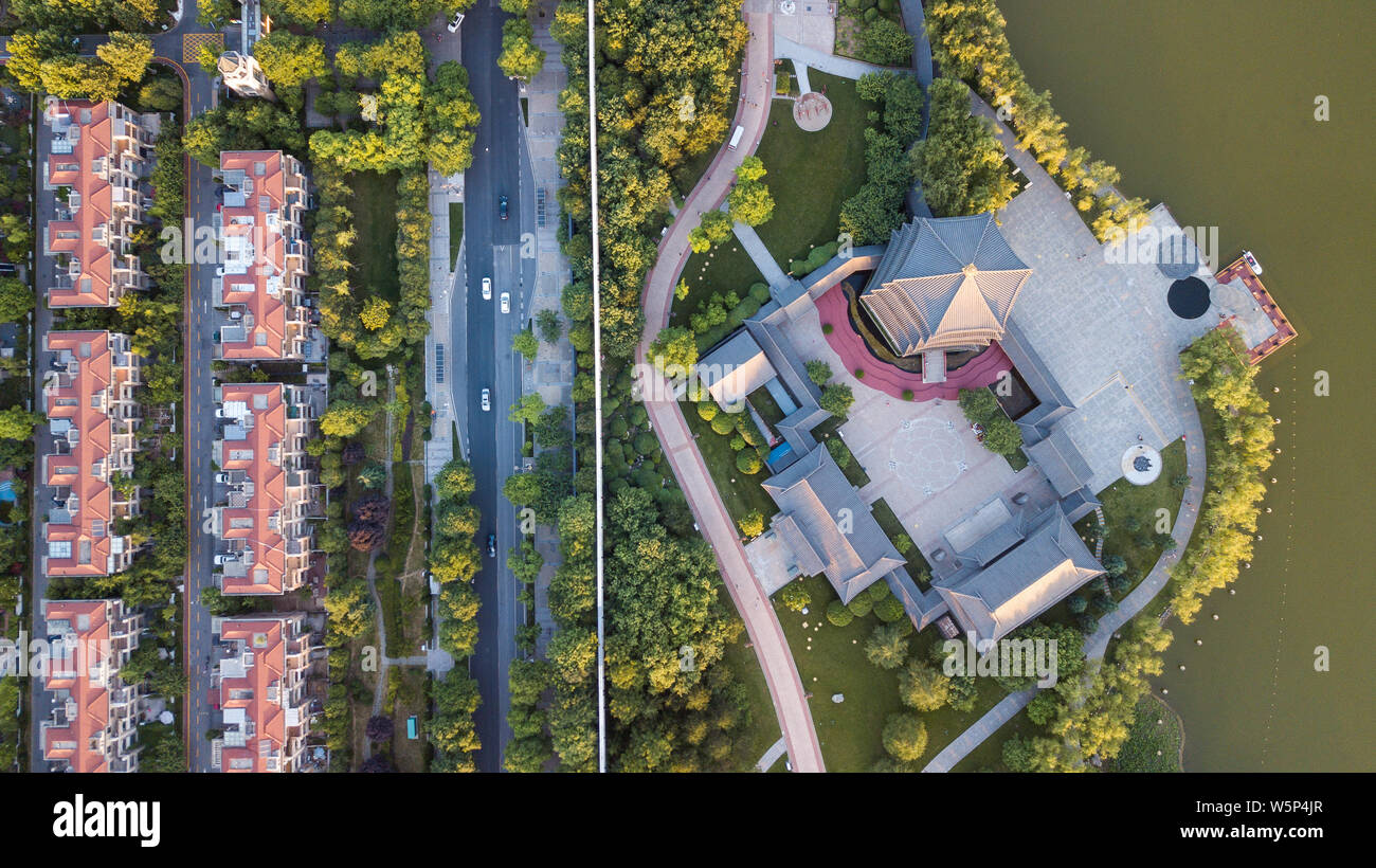 A cluster of villas with red and blue roofs along the Qujiang River in ...