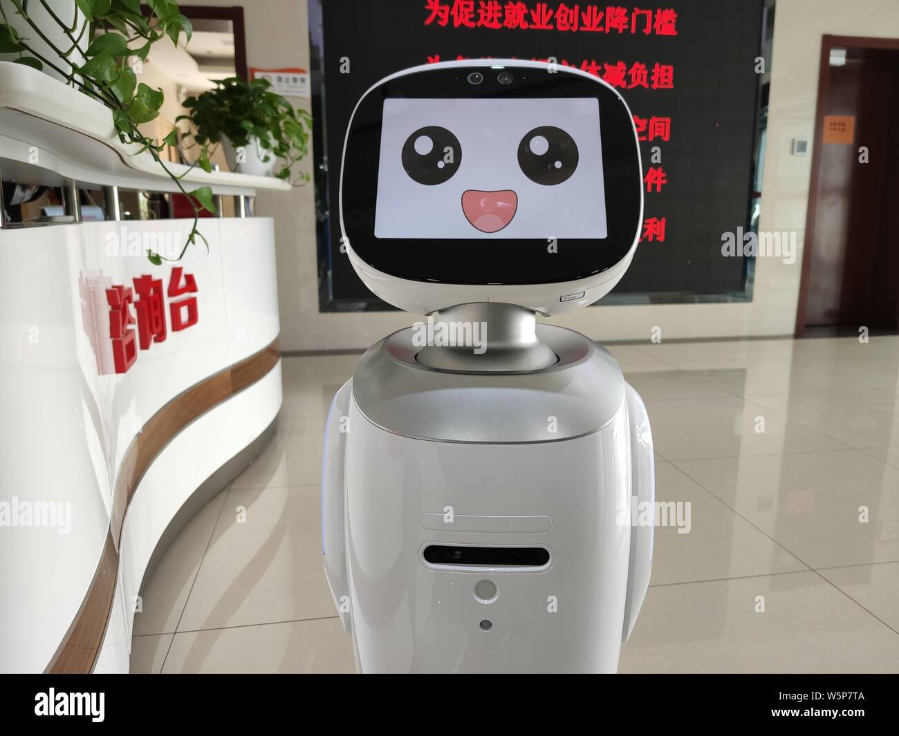 A cute smart guiding robot is seen at a government affair hall in ...