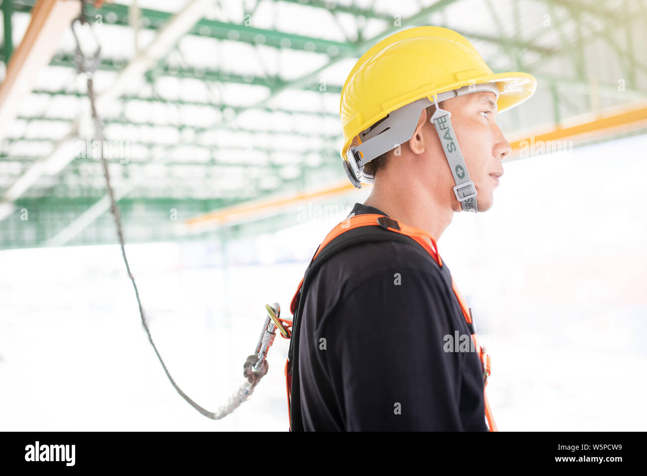 industrial worker wearing the protective harness in the factory, safety ...