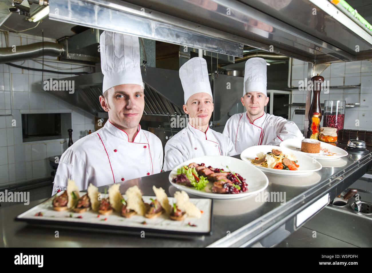 Portrait of a chef with cooked food in the Kitchen in the restaurant ...
