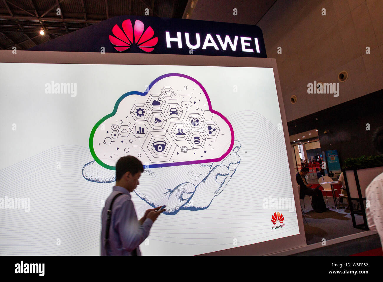 People visit the stand of Chinese tech giant Huawei during an expo in ...