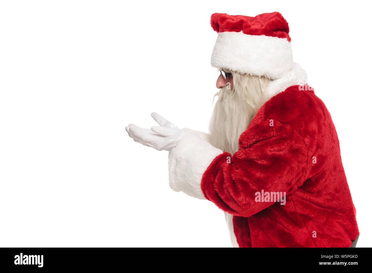 portrait of old santa claus offering something to side while standing ...