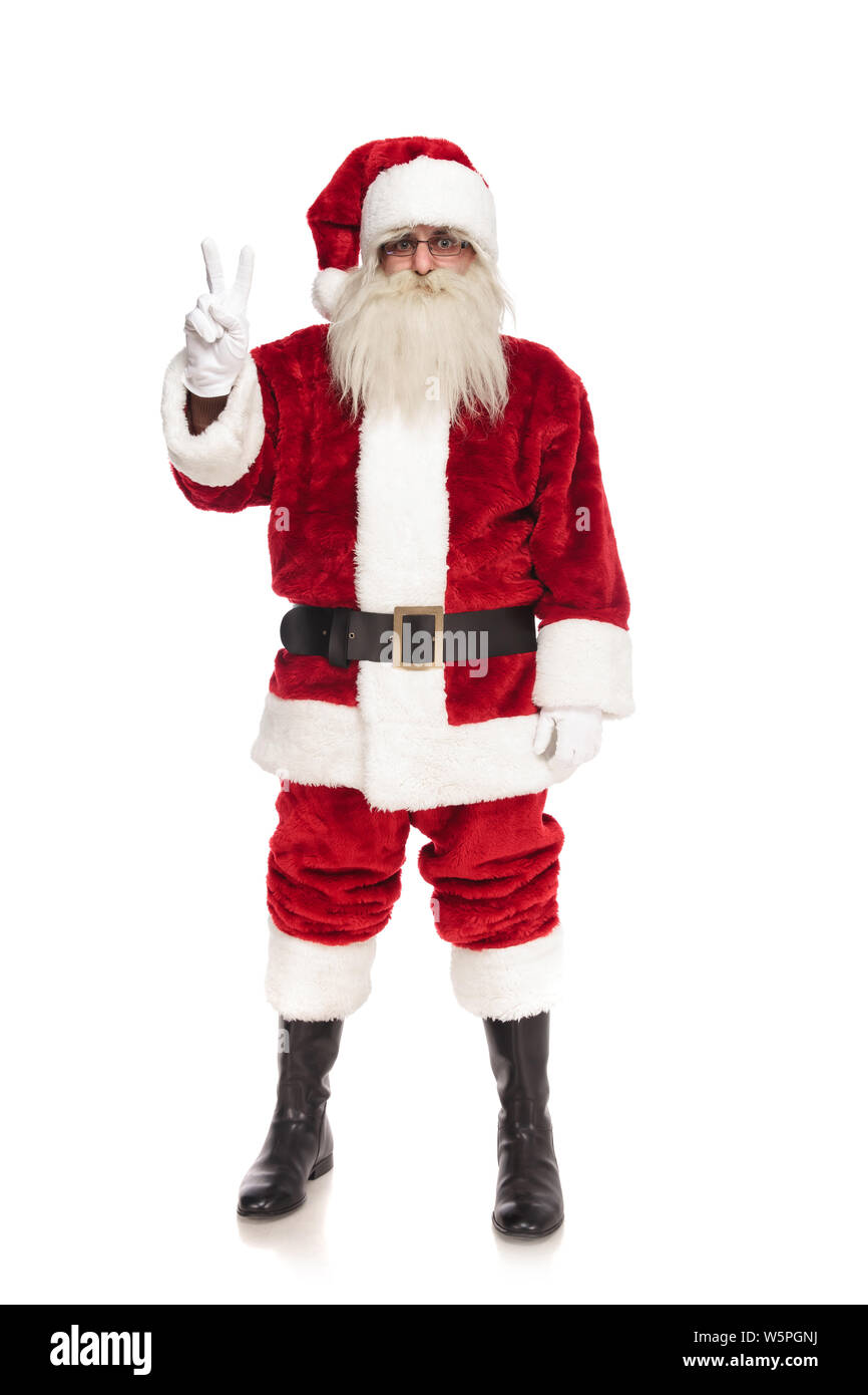 old saint nick wearing red costume makes peace sign while standing on ...