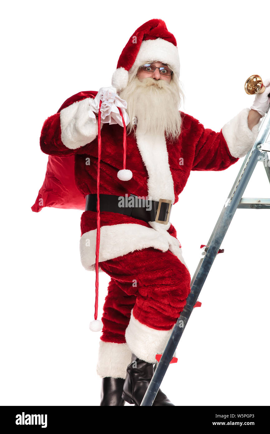santa steps up the ladder to bring presents for christmas while ...
