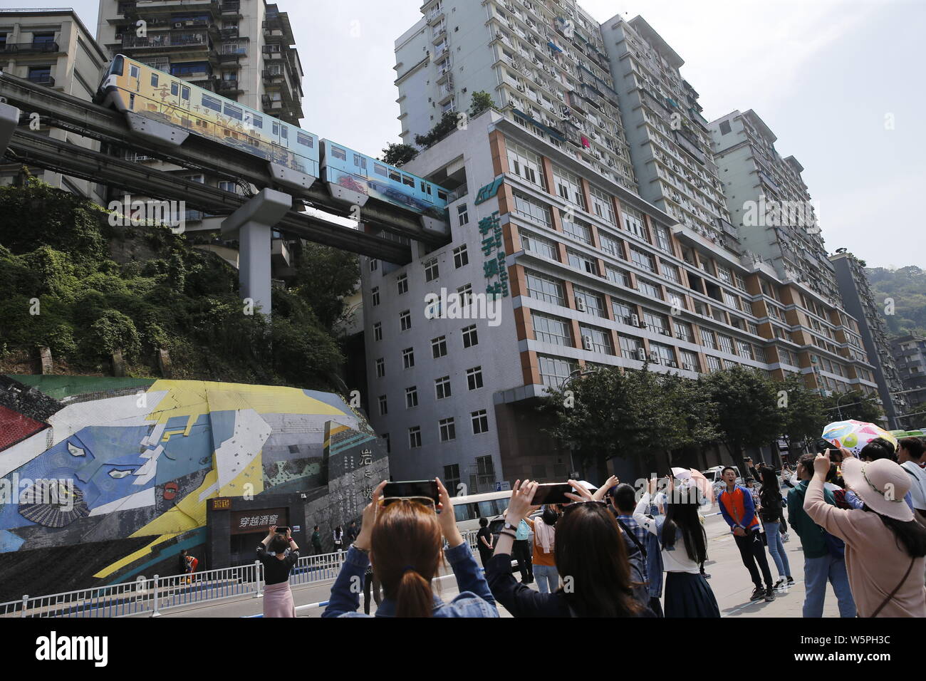 --FILE--People take pictures or videos of a monorail train driving into ...