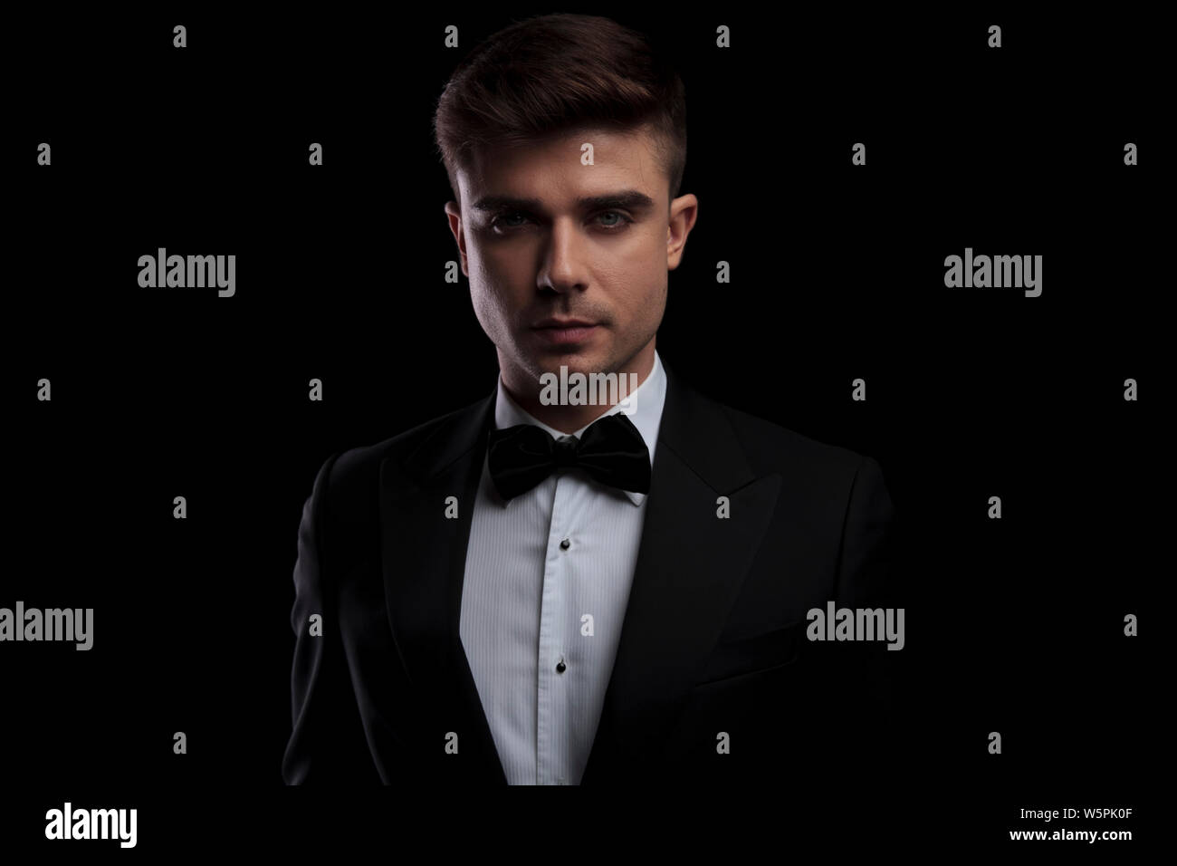 portrait of attractive elegant man wearing a black suit and standing on ... portrait of attractive elegant man wearing a black suit and standing on ...