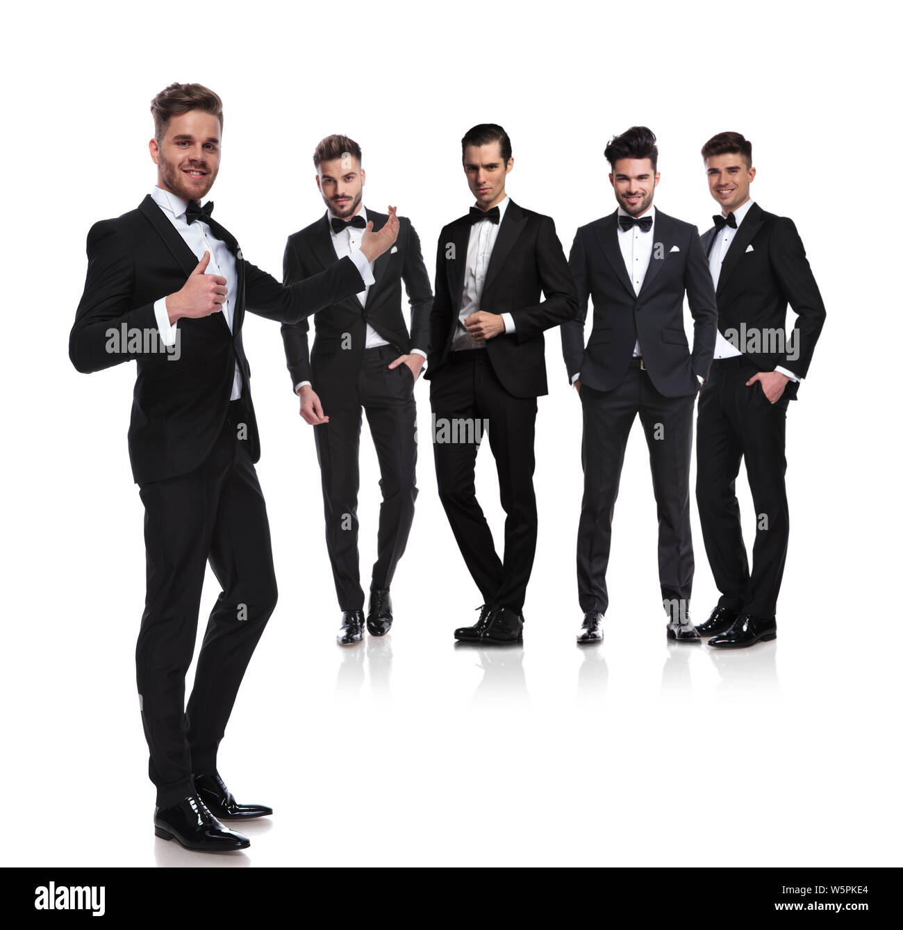 elegant groomsman presenting his friends while standing in front and ...