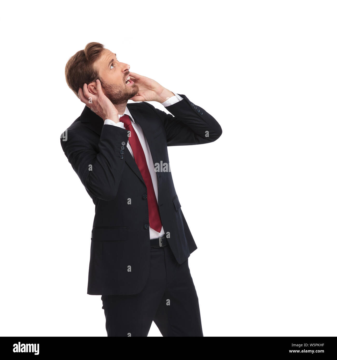 portrait of frightened businessman looking up to side while standing on ...