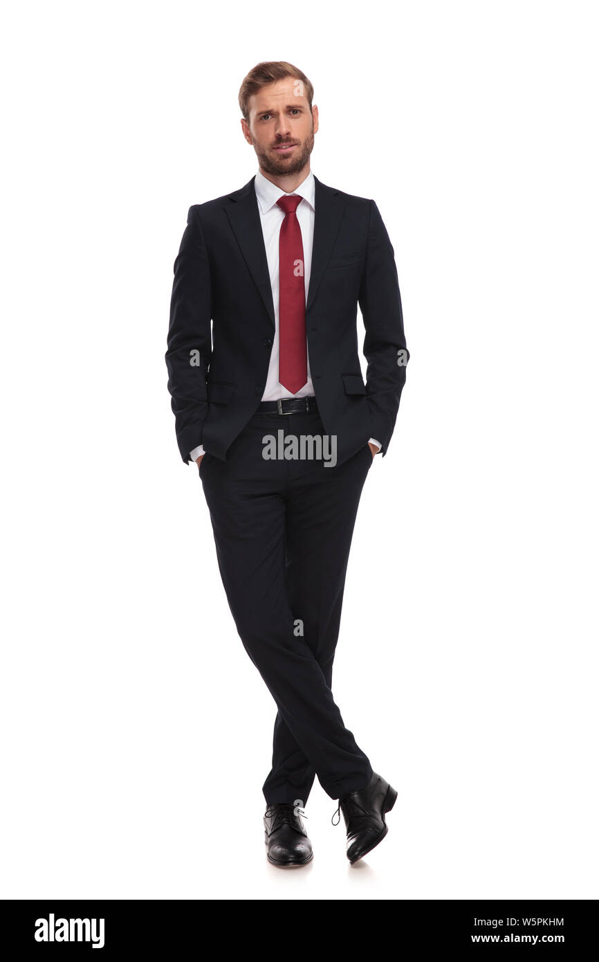 sad businessman stands with hands in pockets and legs crossed on white ...