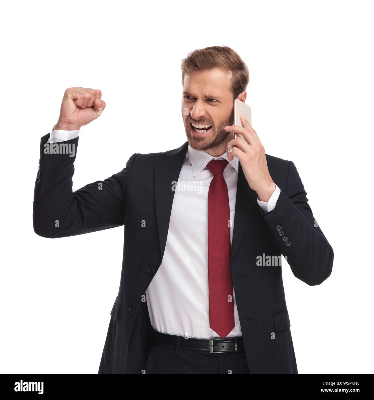 portrait of excited businessman talking on the phone and celebrating ...