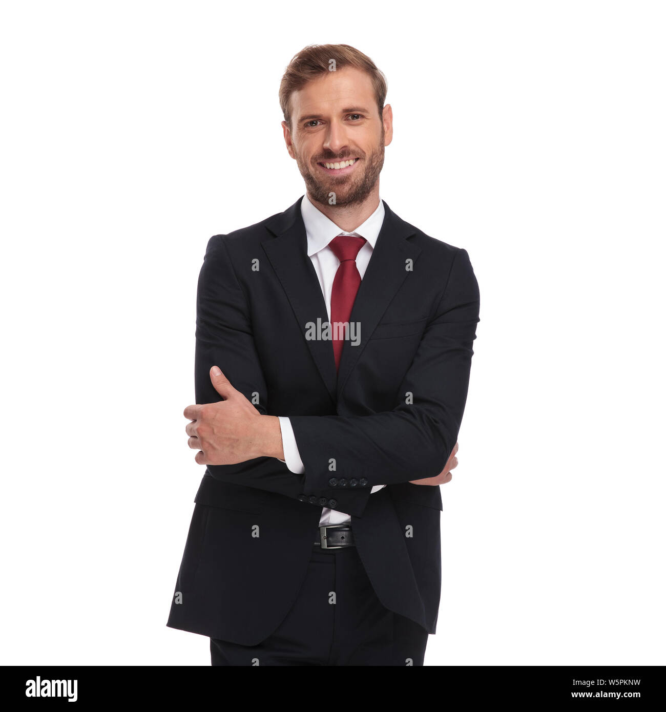 portrait of confident businessman smiling and standing with arms folded ...