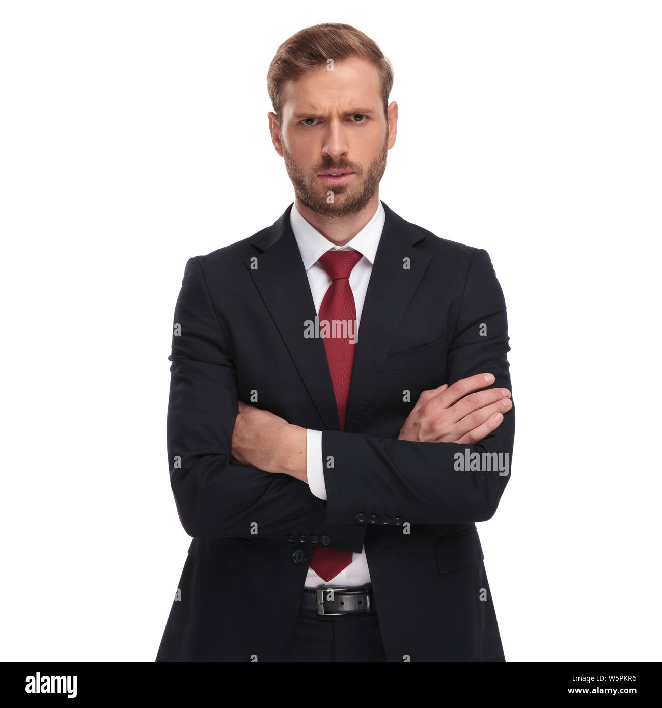 portrait of angry businessman with folded arms standing on white ...