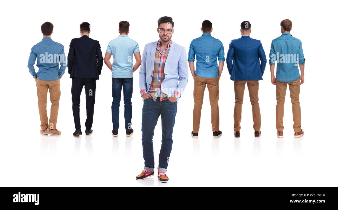 back view of six men standing with hands in pockets with casual team ...