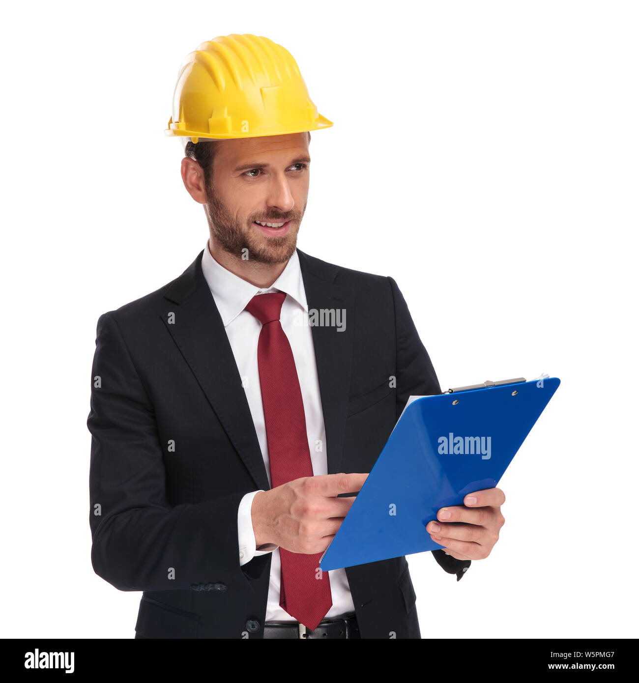 young engineer ceo holding blue clipboard looks to side while standing ...
