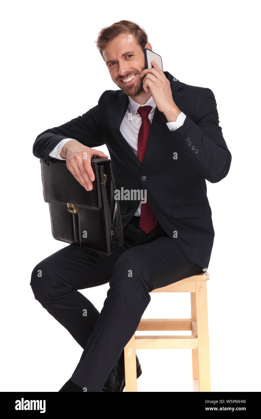 happy businessman sitting on wooden chair and waiting for interview ...